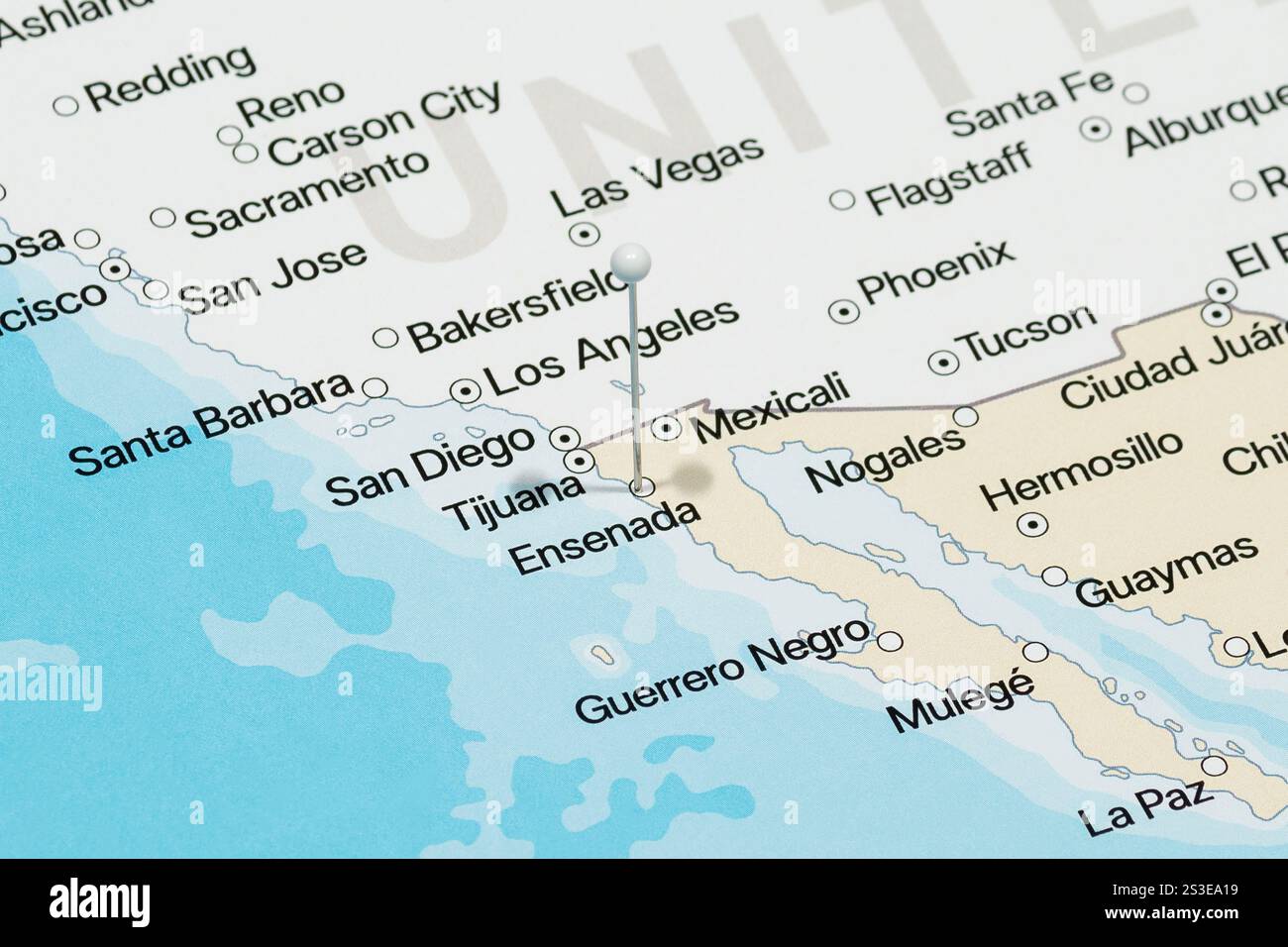 Macro photo of a white pin needle into Ensenada of Mexico political map ...