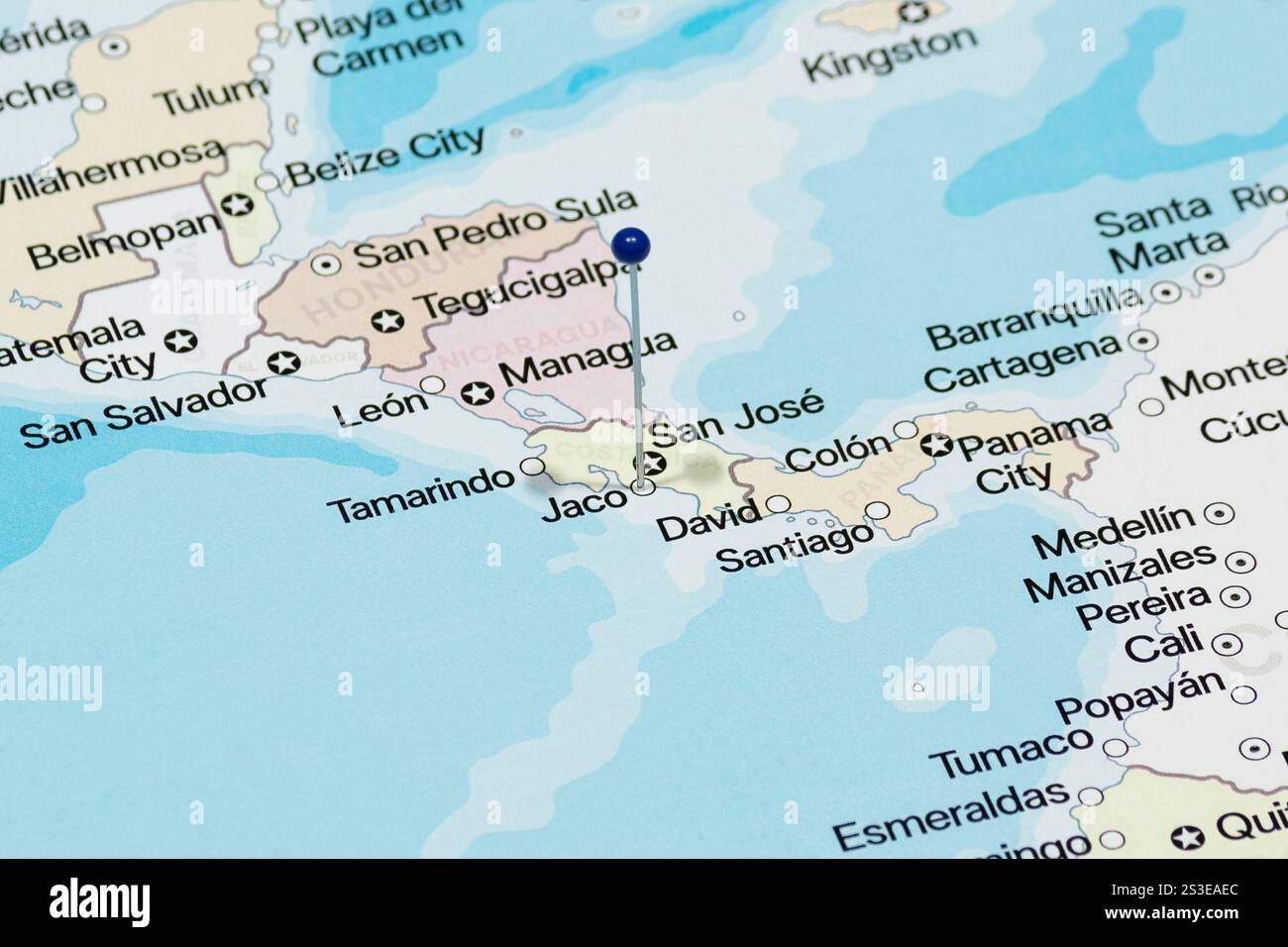 Macro photo of a blue pin needle into Jaco city of Costa Rica political ...