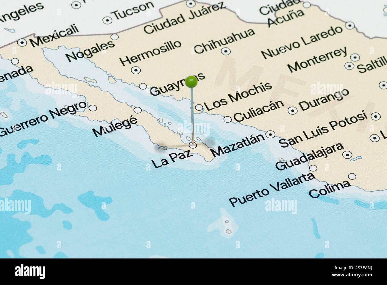 Macro photo of a green pin needle into La Paz of Mexico political map ...