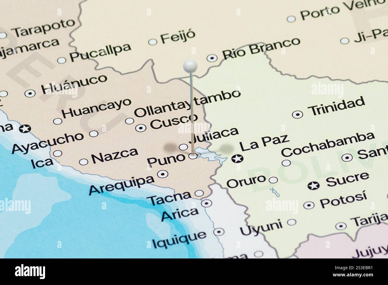 Macro photo of a white pin needle into Puno city of Peru political map ...