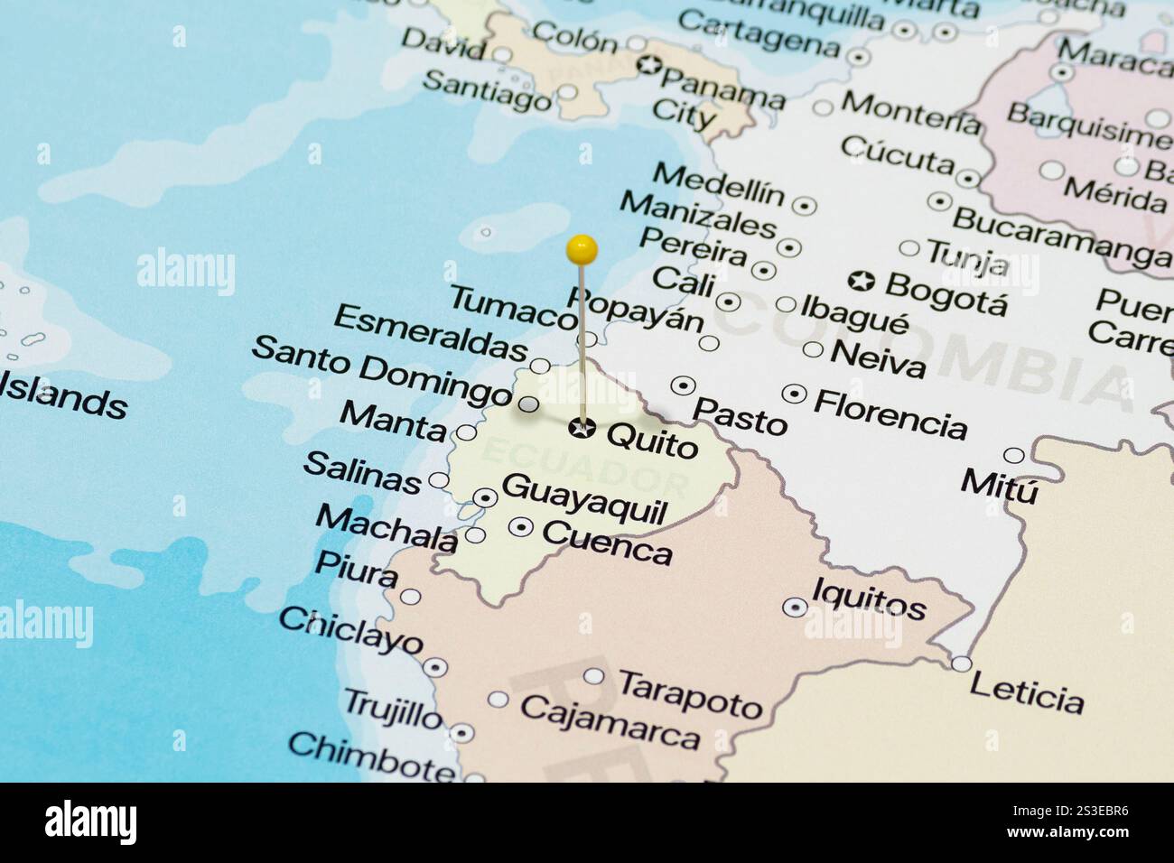 Macro photo of a yellow pin needle into Quito city of Ecuador political ...