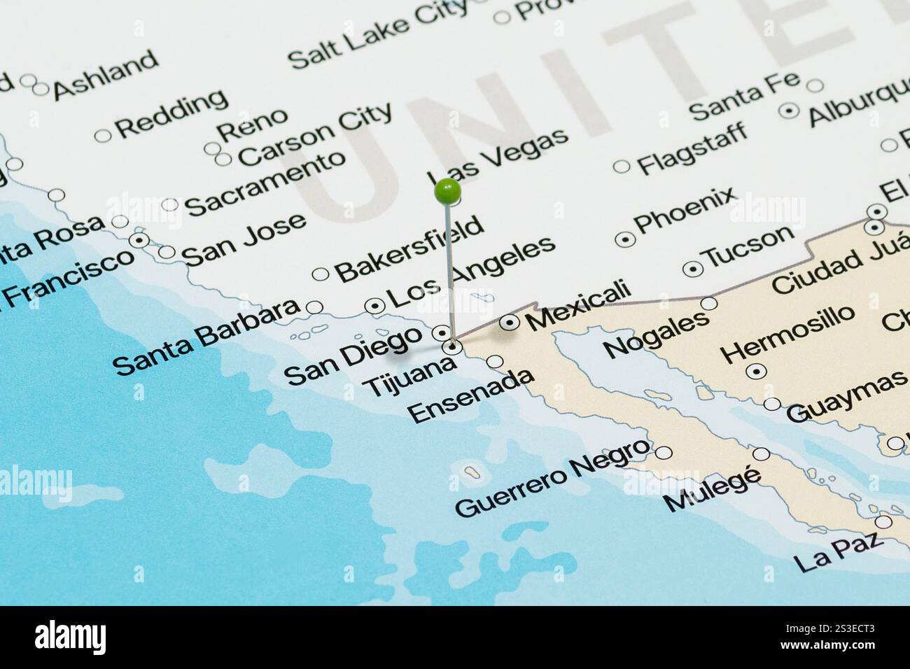 Macro photo of a green pin needle into Tijuana city of Mexico political ...