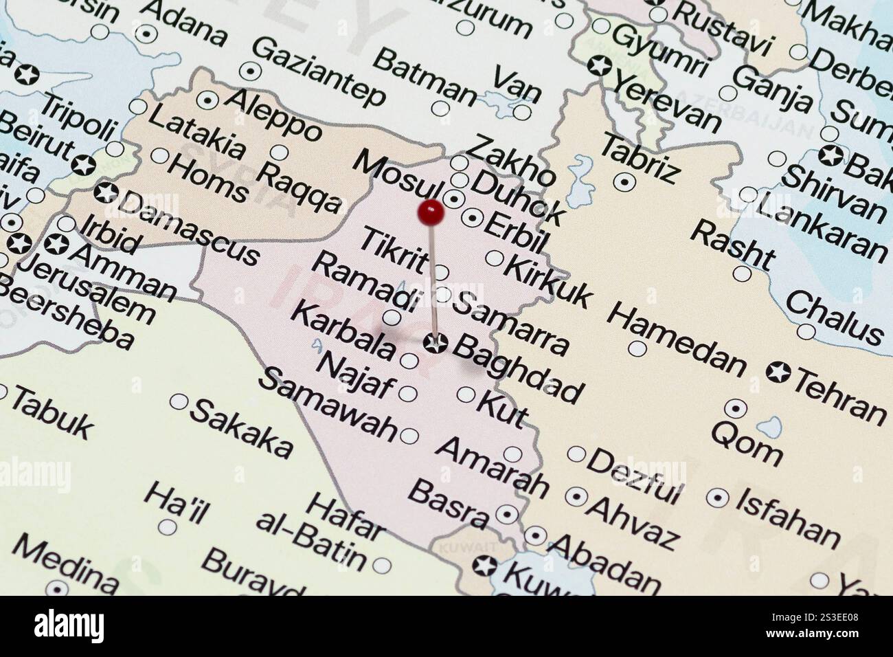 Macro photo of a red pin needle into Baghdad city of Iraq political map ...
