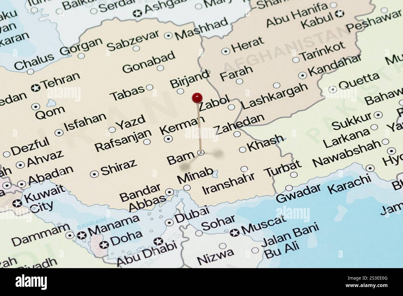 Macro photo of a red pin needle into Bam city of Iran political map ...