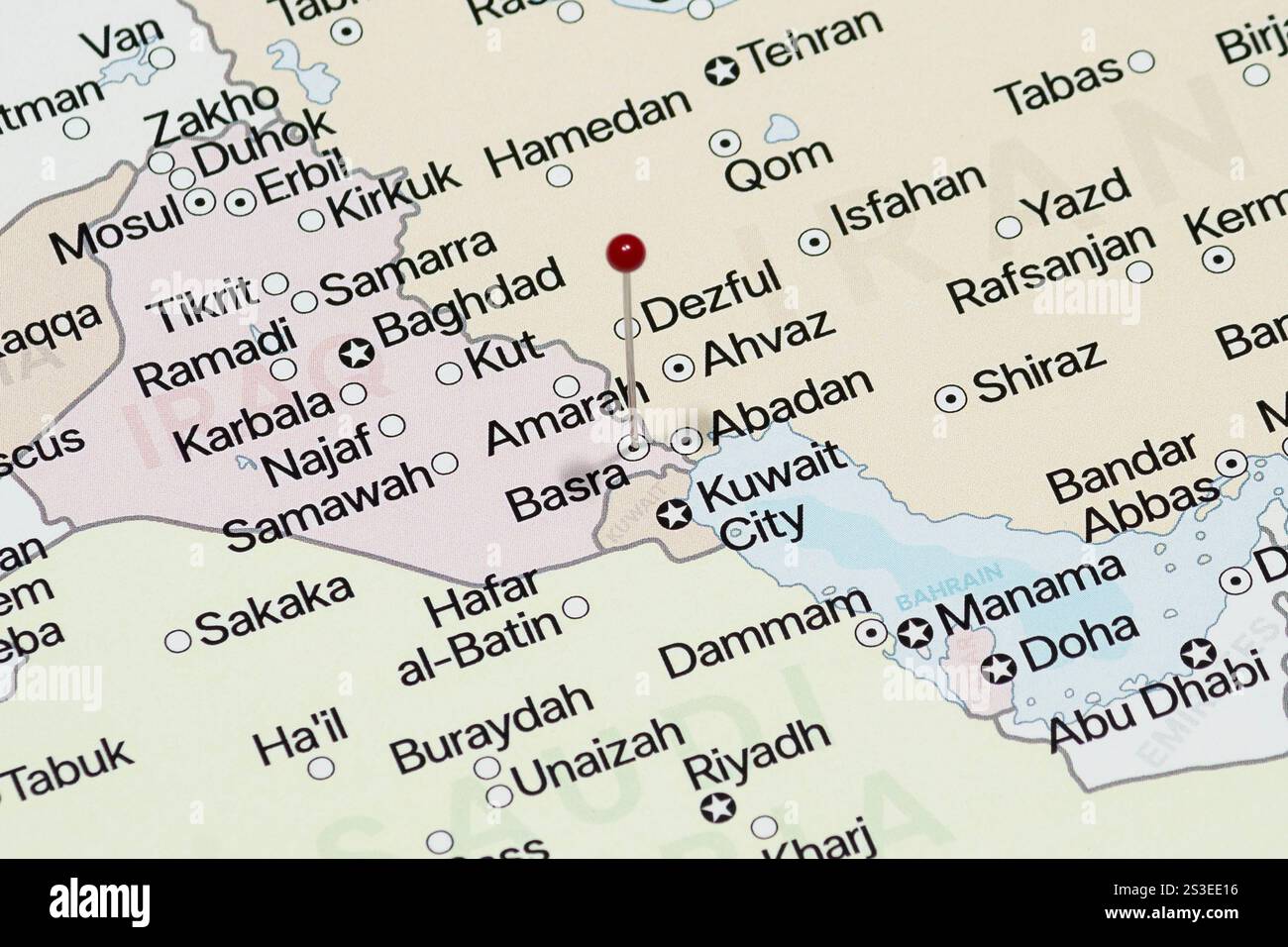 Macro photo of a red pin needle into Basra city of Iraq political map ...
