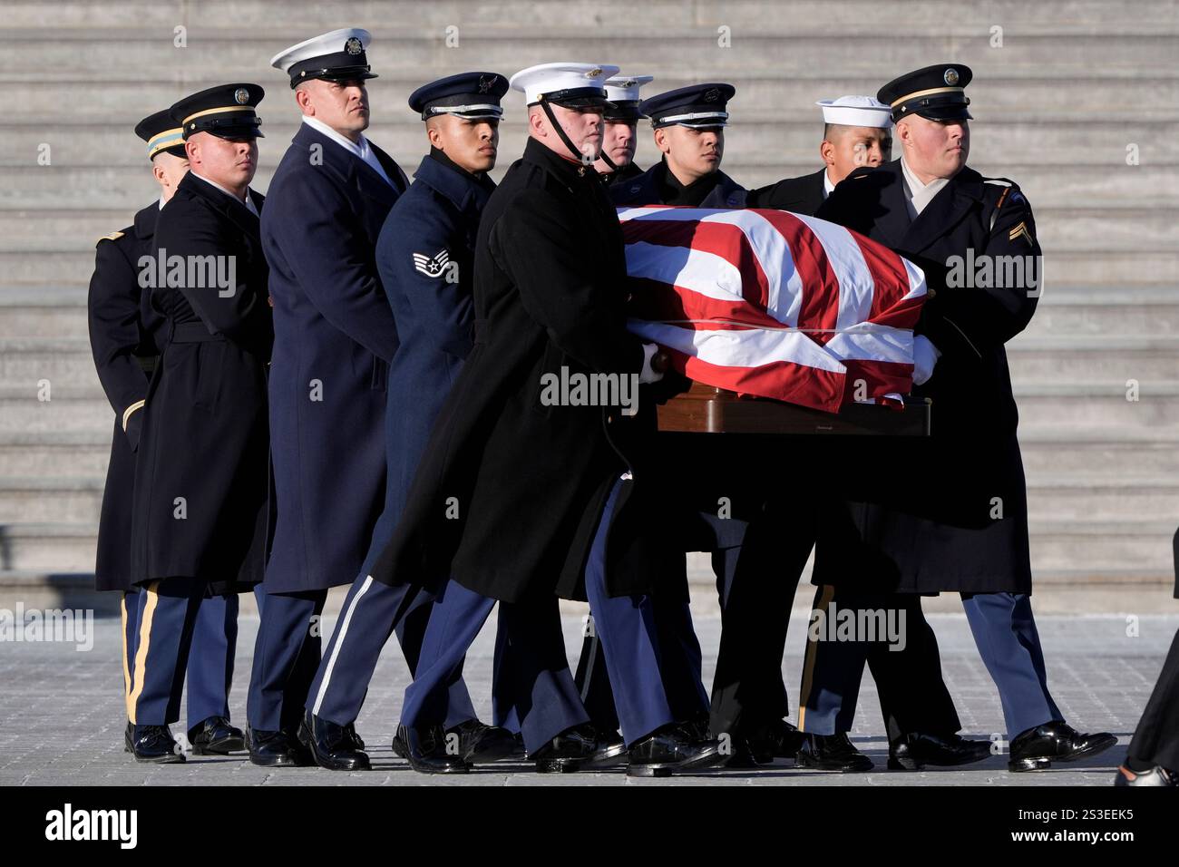 The flag-draped casket of former President Jimmy Carter is carried from ...