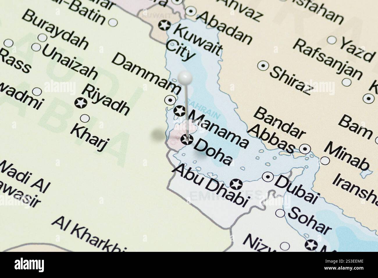 Macro photo of a white pin needle into Doha city of Qatar political map ...