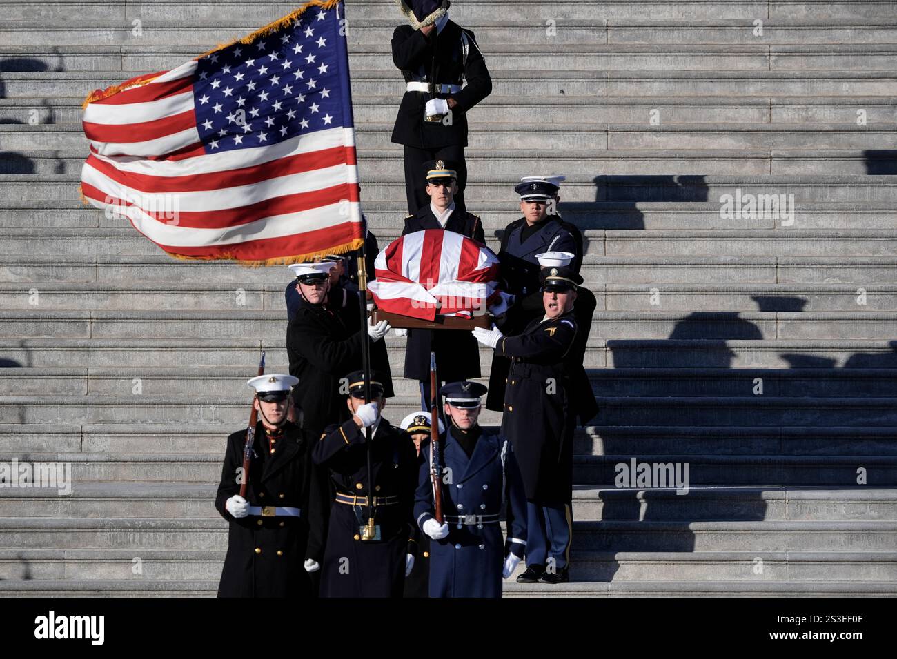 The flag-draped casket of former President Jimmy Carter is carried from ...