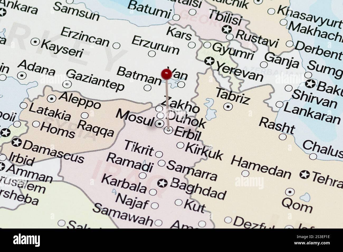 Macro photo of a red pin needle into Erbil city of Iraq political map ...