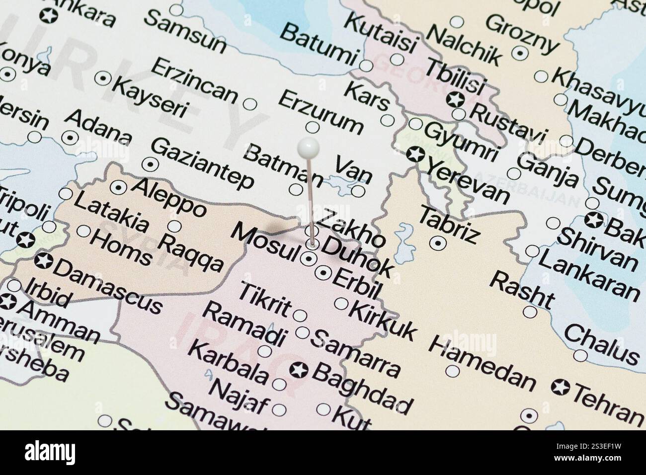 Macro photo of a white pin needle into Duhok city of Iraq political map ...