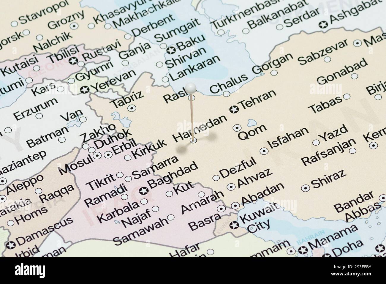 Macro photo of a red pin needle into Hamadan city of Iran political map ...