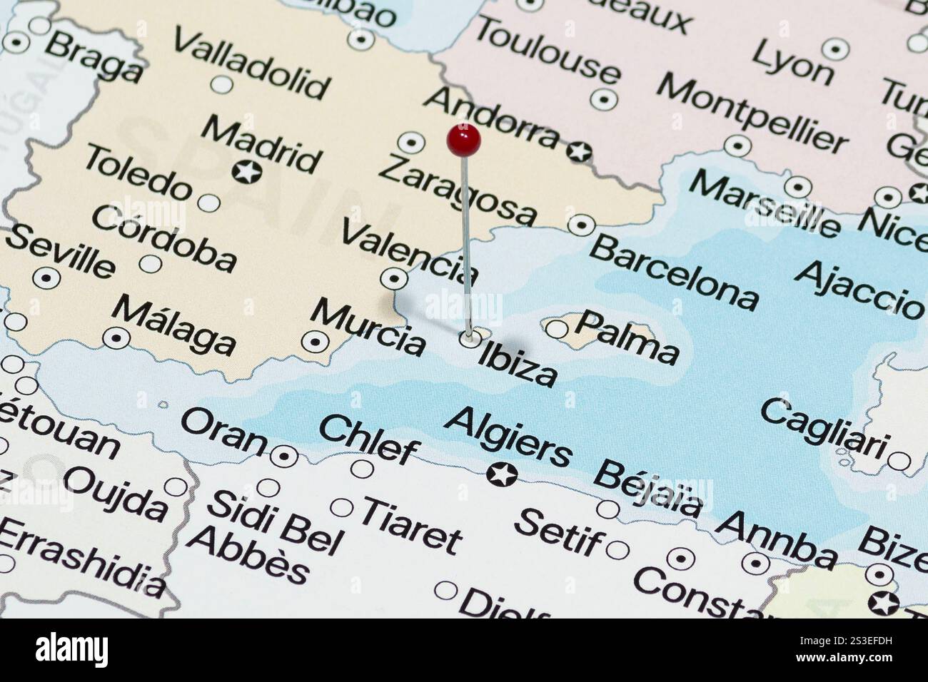 Macro photo of a red pin needle into Ibiza city of Spain political map ...