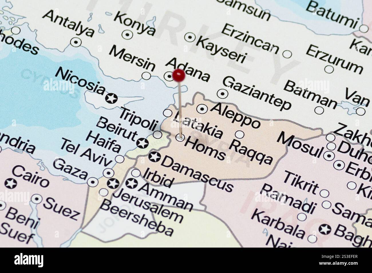 Macro photo of a red pin needle into Homs city of Syria political map ...