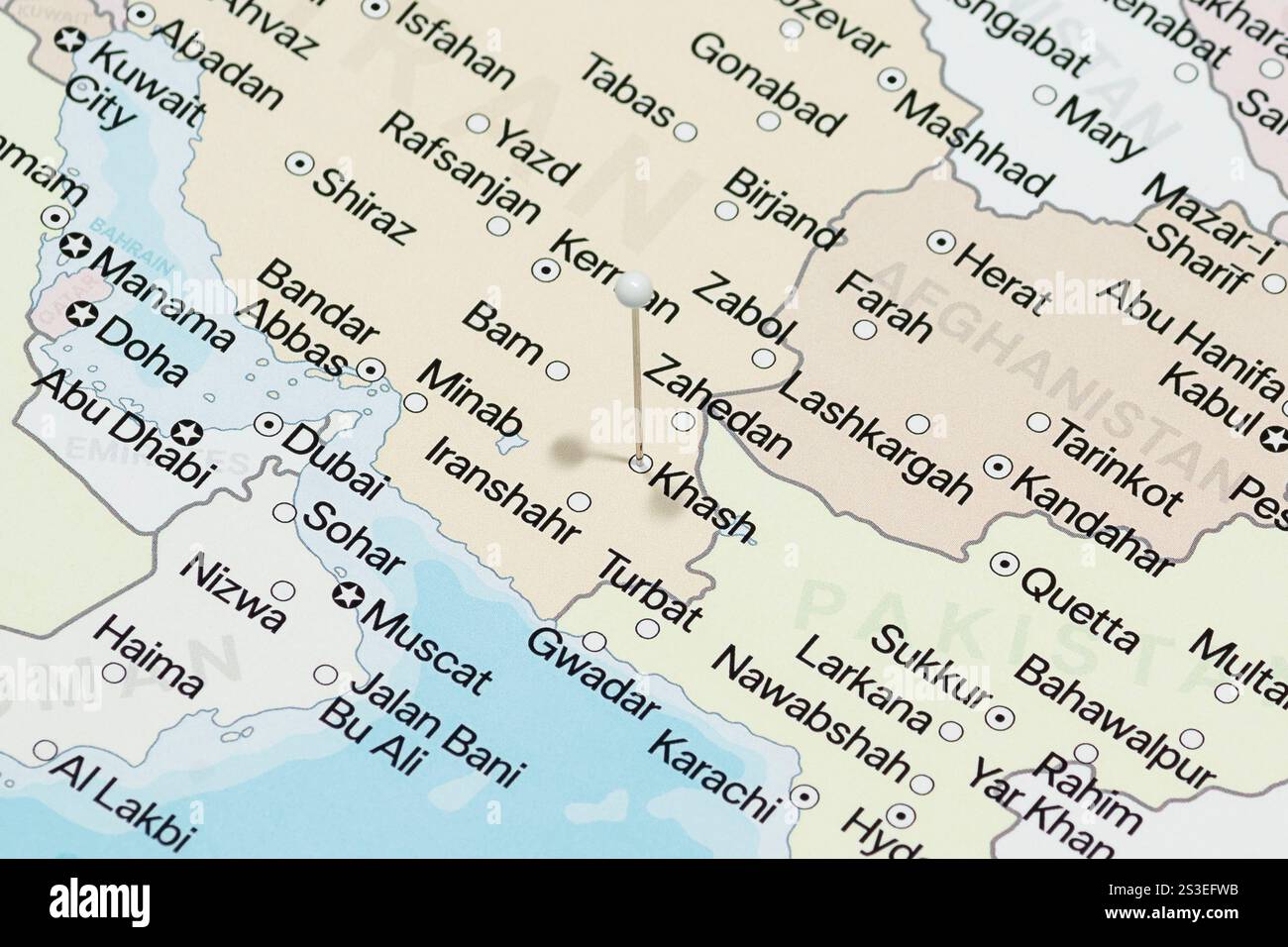Macro photo of a white pin needle into Khash city of Iran political map ...