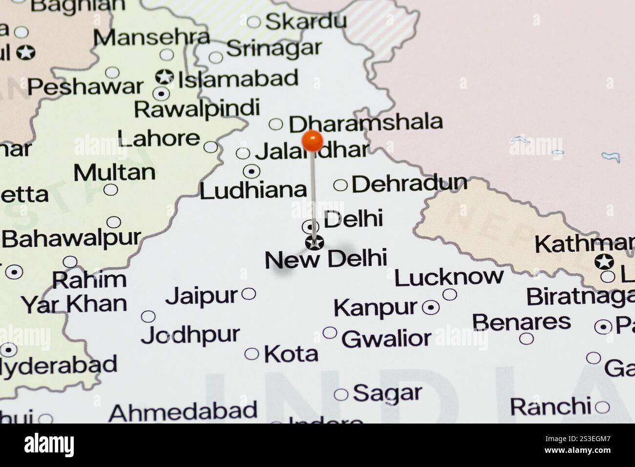 Close up to an orange pin needle into New Delhi city of India political ...