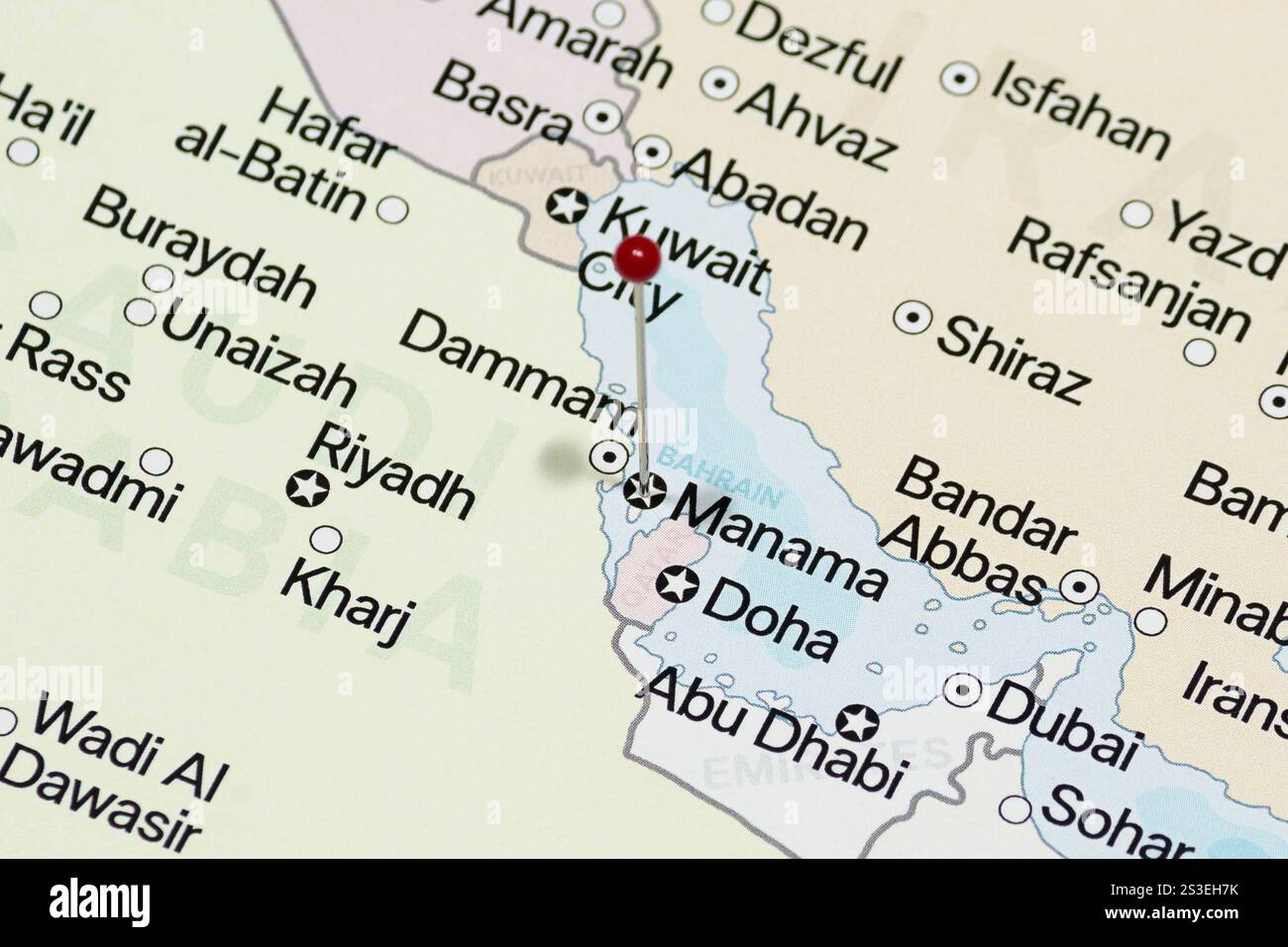 Macro photo of a red pin needle into Manama city of Bahrain political ...