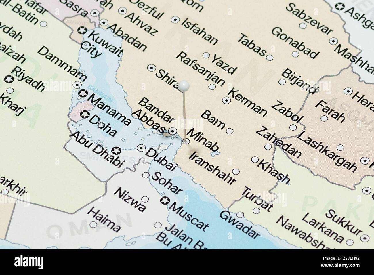 Macro photo of a white pin needle into Minab of Iran political map ...