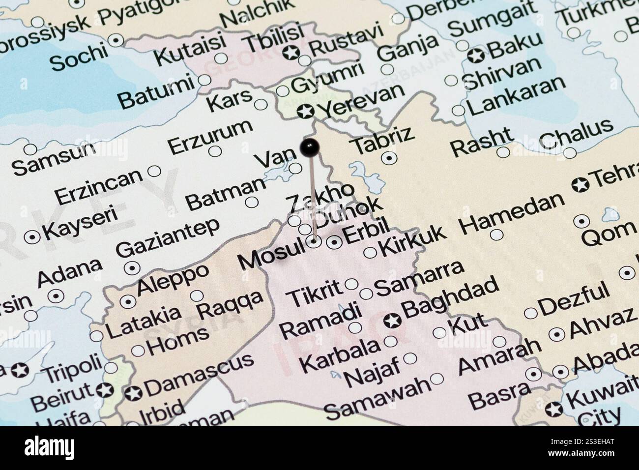 Macro photo of a black pin needle into Mosul city of Iraq political map ...
