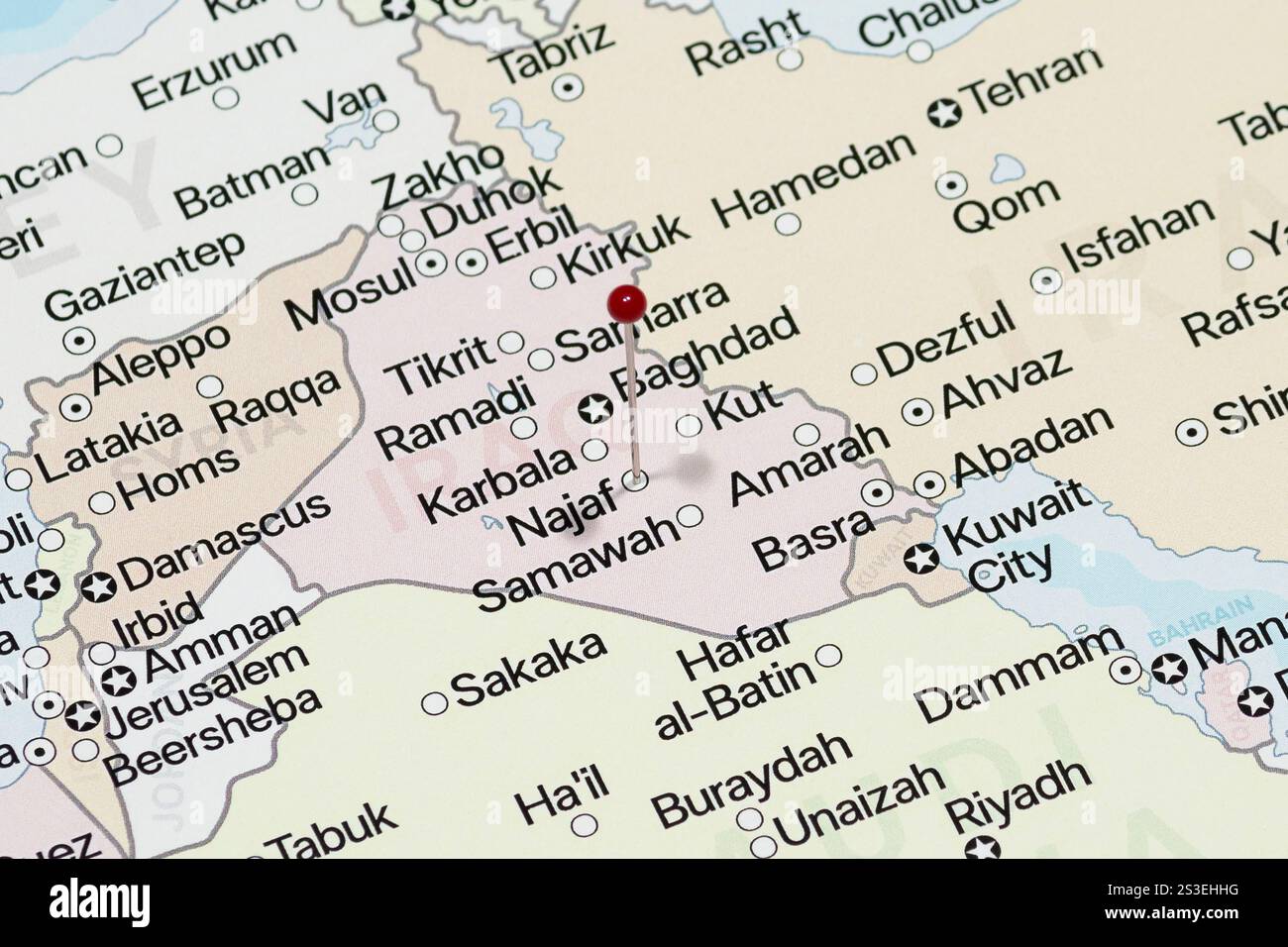 Macro photo of a red pin needle into Najaf city of Iraq political map ...