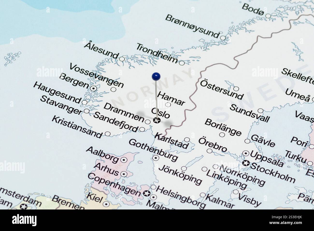 Macro photo of a blue pin needle into Oslo city of Norway political map ...