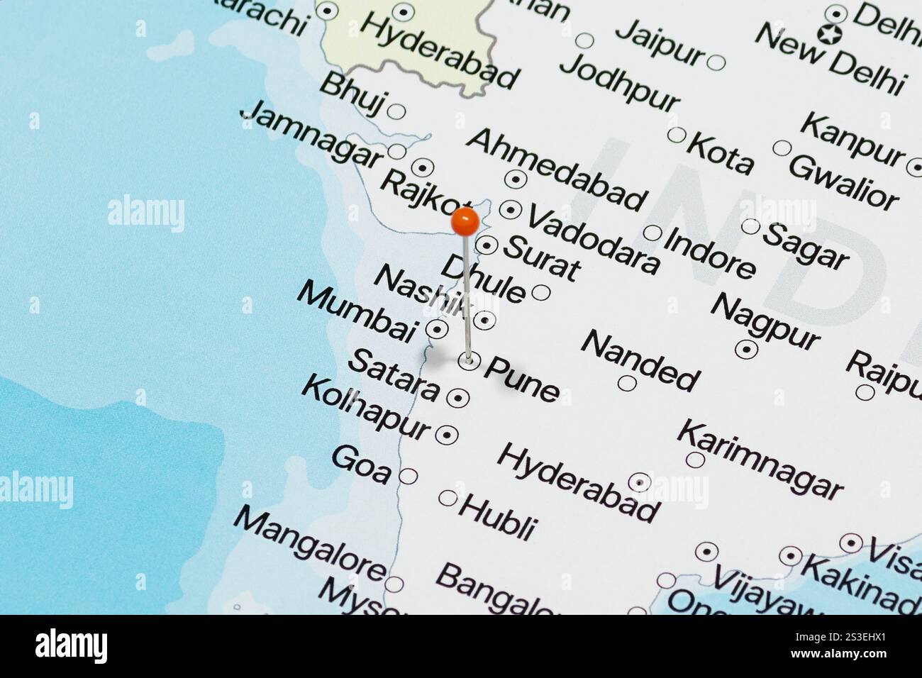 Macro photo of an orange pin needle into Pune city of India political ...