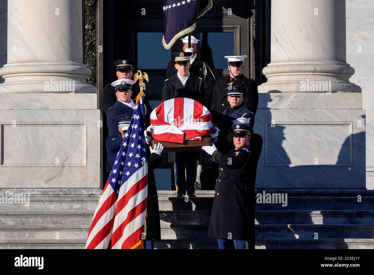 The flag-draped casket of former President Jimmy Carter is carried from ...