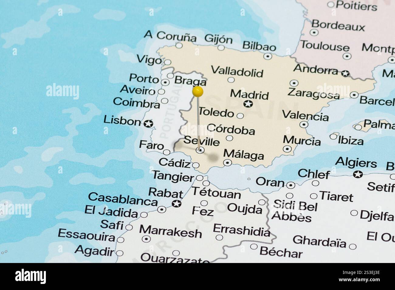 Macro photo of a yellow pin needle into Seville city of Spain political ...