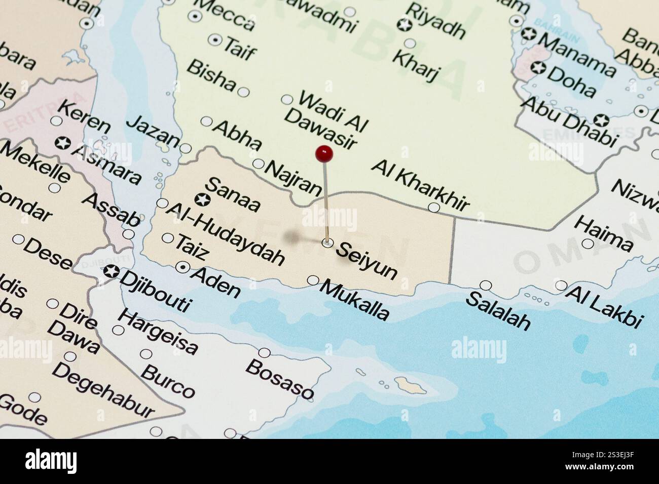 Macro photo of a red pin needle into Seiyun city of Yemen political map ...