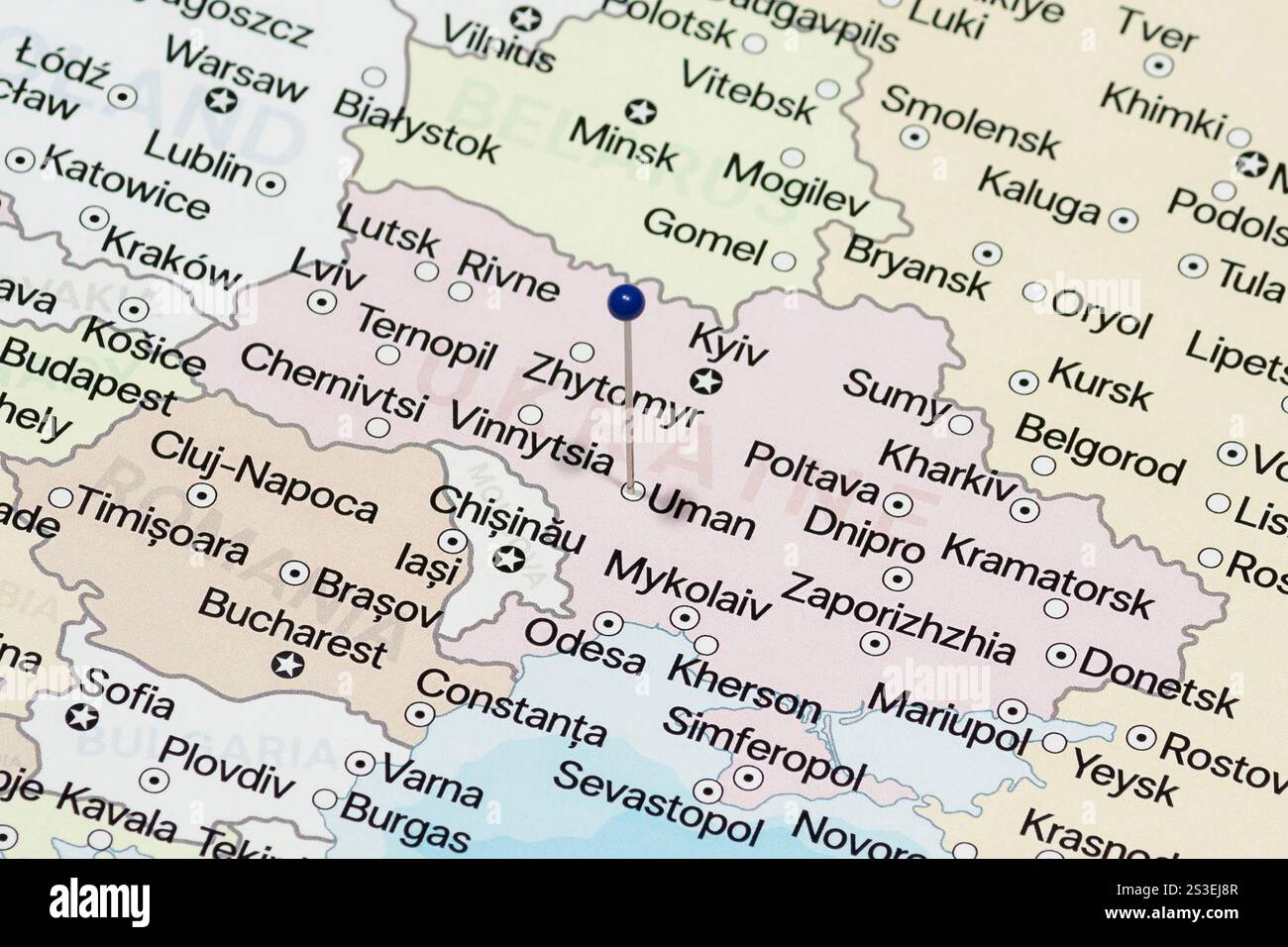 Macro photo of a blue pin needle into Uman city of Ukraine political ...