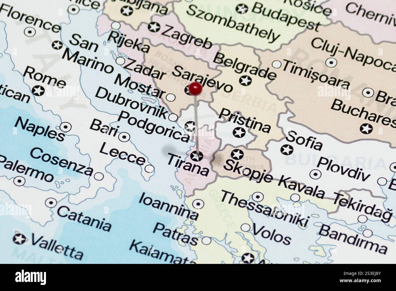 Macro photo of a red pin needle into Tirana city of Albania political ...