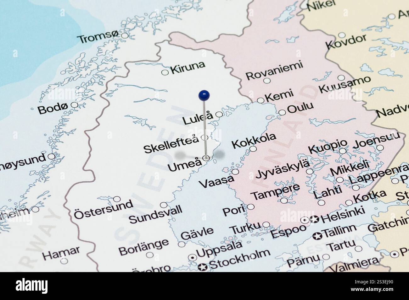 Macro photo of a blue pin needle into Umea city of Sweden political map ...