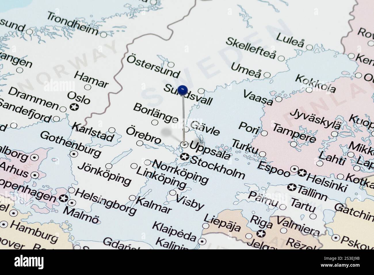 Macro photo of a blue pin needle into Uppsala city of Sweden political ...