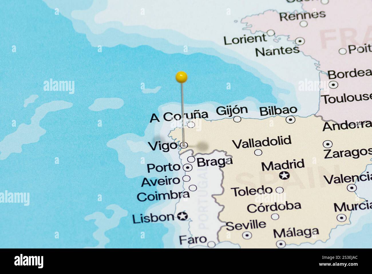 Macro photo of a yellow pin needle into Vigo city of Spain political ...