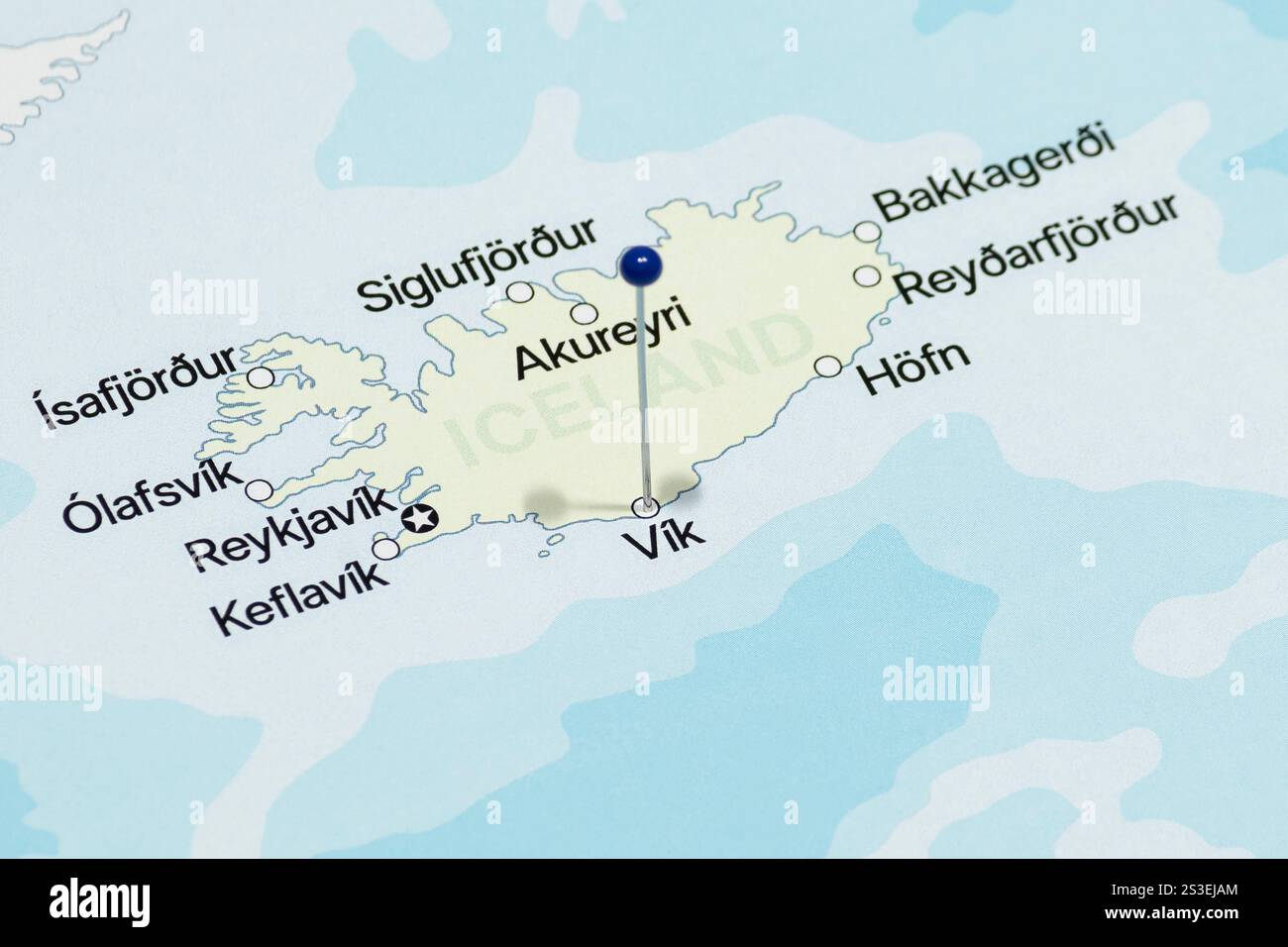 Macro photo of a blue pin needle into Vik city of Iceland political map ...