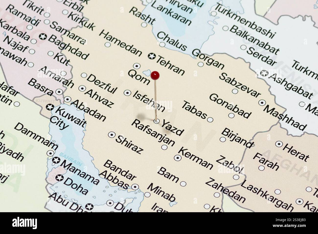 Macro photo of a red pin needle into Yazd city of Iran political map ...