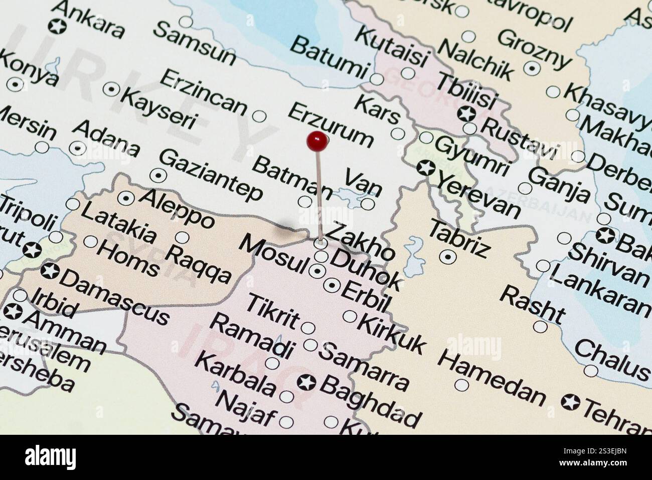 Macro photo of a red pin needle into Zakho city of Iraq political map ...
