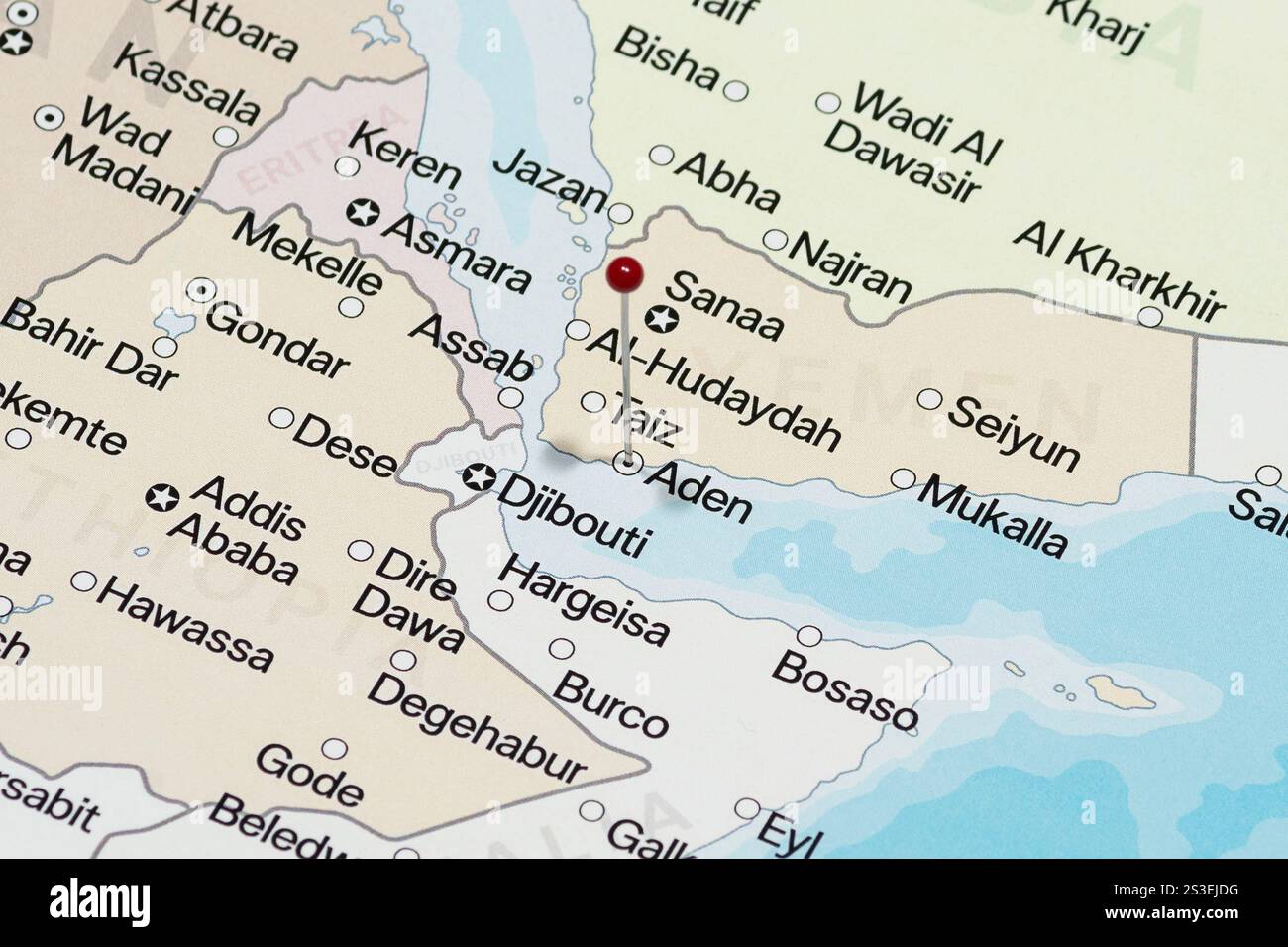 Macro photo of a red pin needle into Aden city of Yemen political map ...