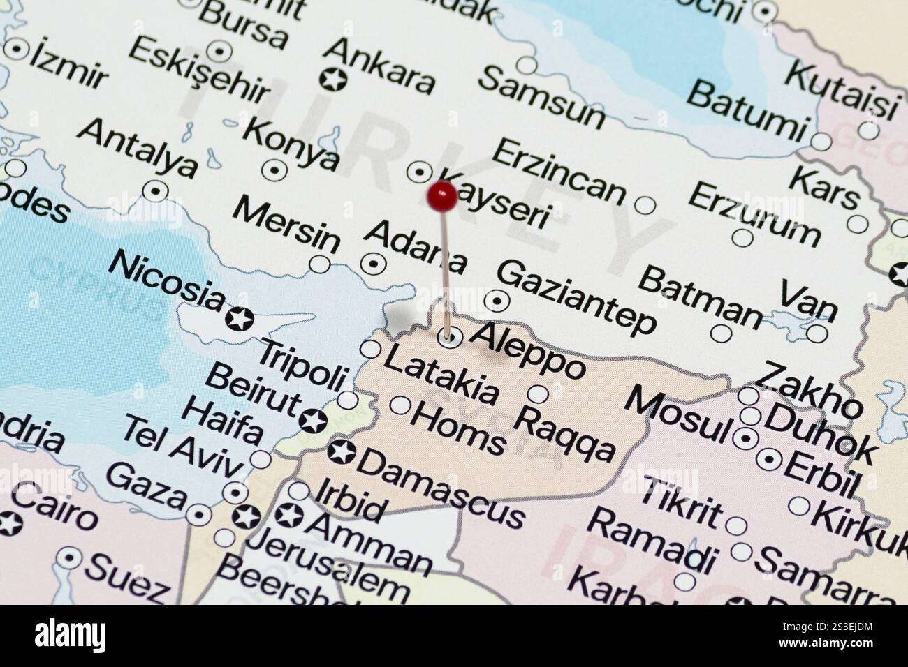 Macro photo of a red pin needle into Aleppo city of Syria political map ...