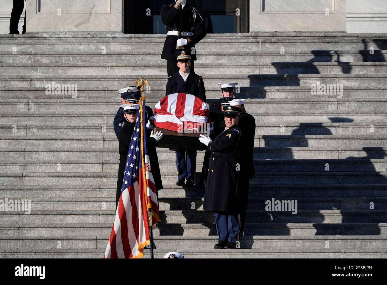 The flag-draped casket of former President Jimmy Carter is carried from ...