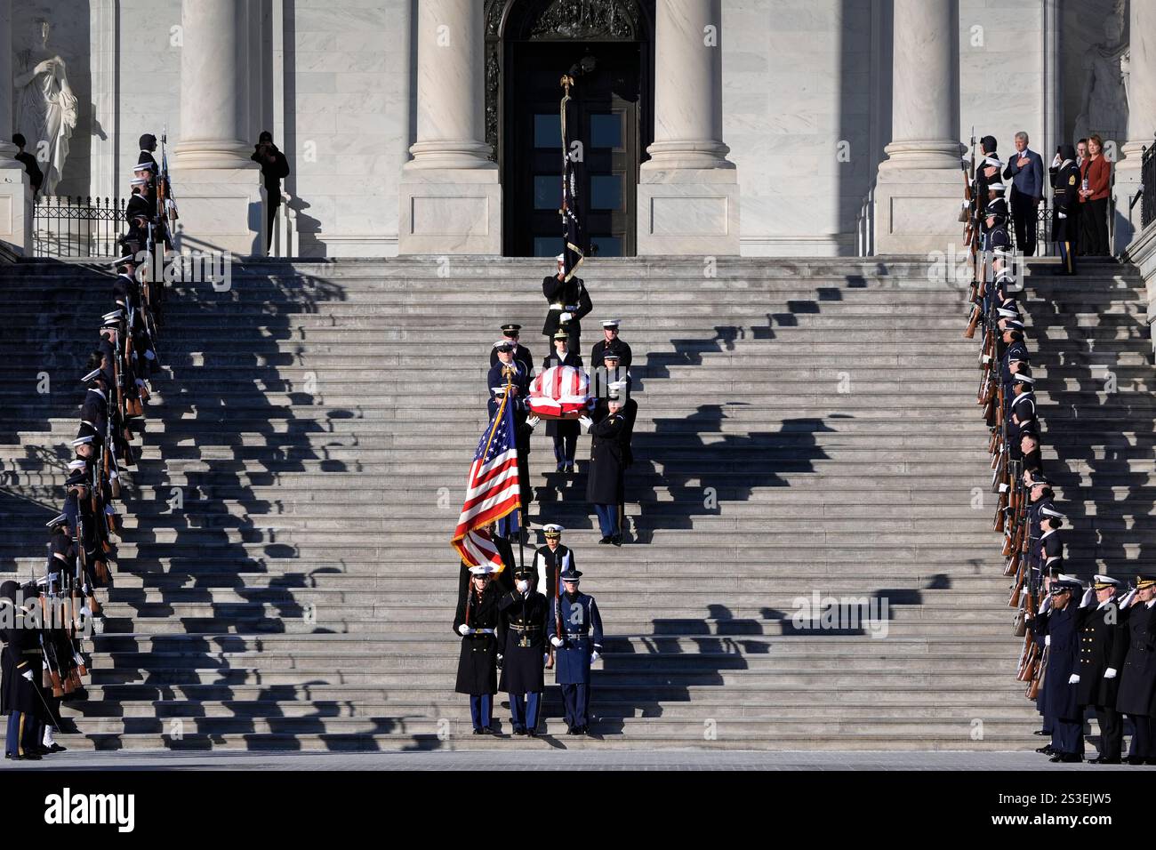 The flag-draped casket of former President Jimmy Carter is carried from ...