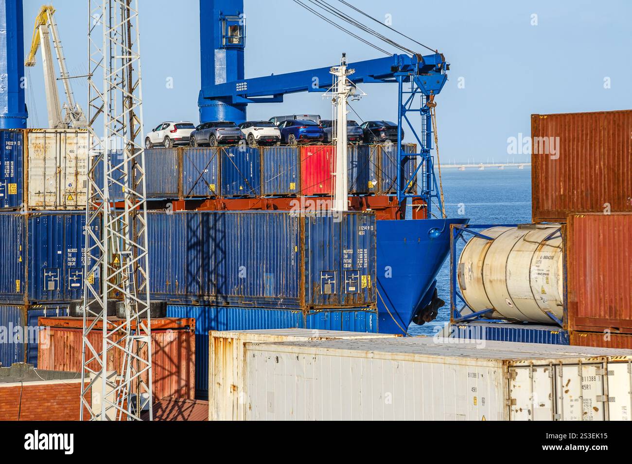 Cargo and tank containers stacked with cars on top on bulk carrier in ...