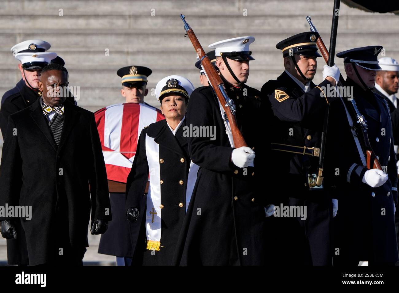 The flag-draped casket of former President Jimmy Carter is carried from ...