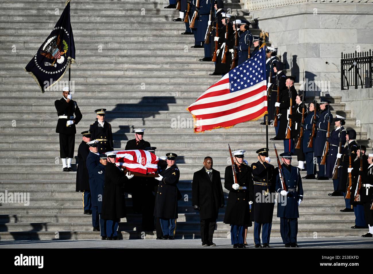 A joint services body bearer team carries the flag-draped casket of ...
