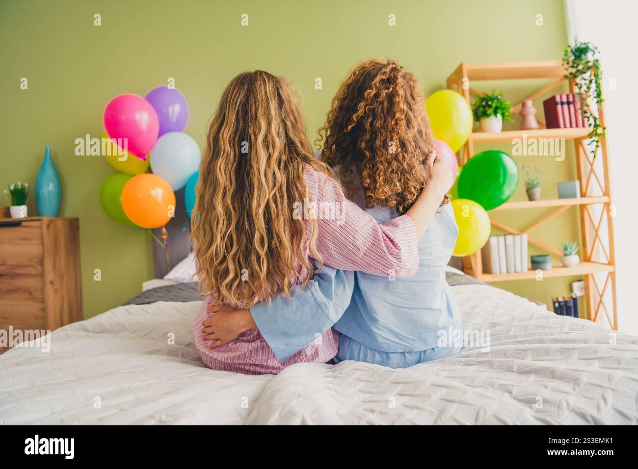 Full length photo of two pretty young females hugging cuddle back view ...