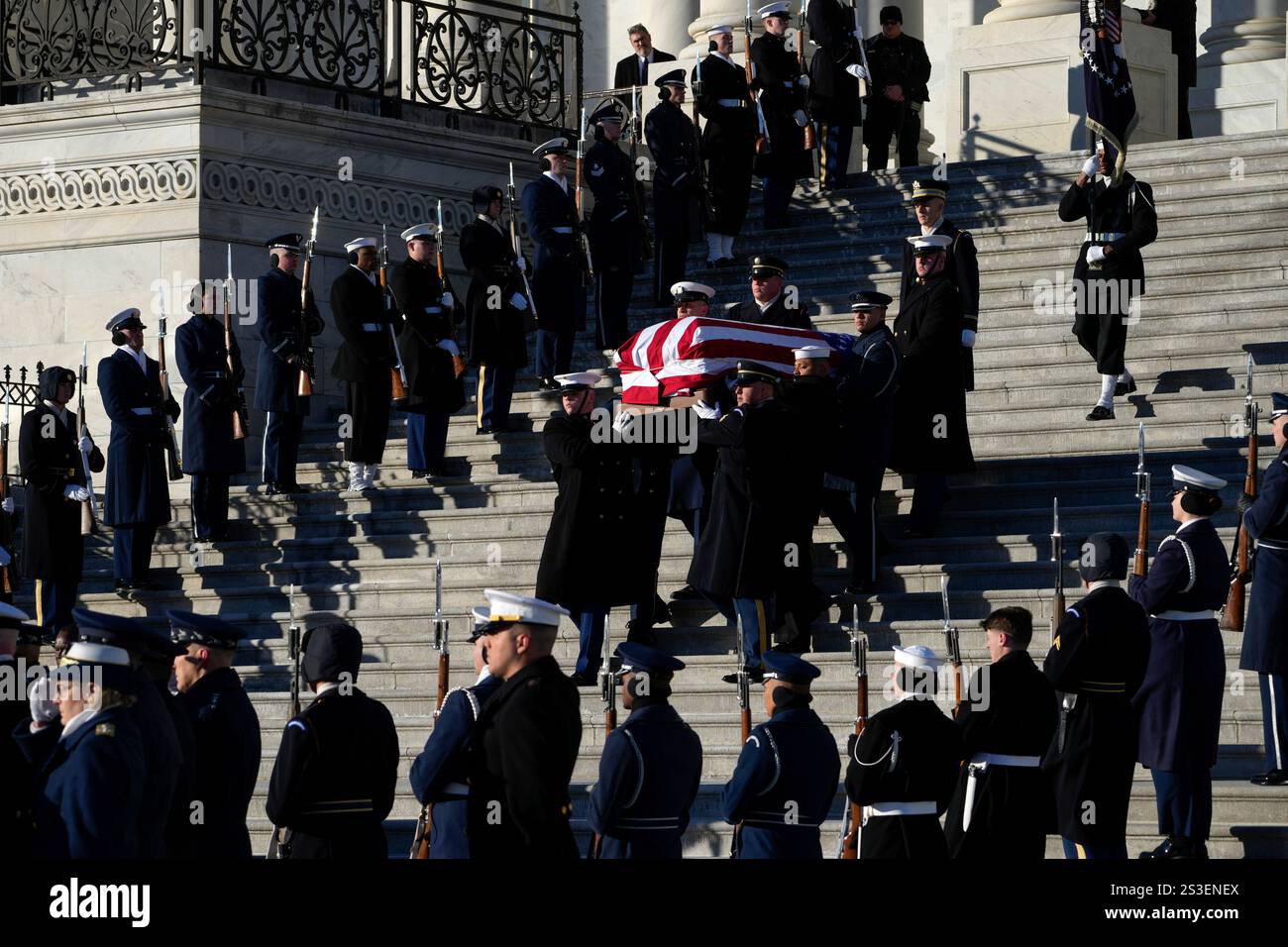 A joint services body bearer team carries the flag-draped casket of ...
