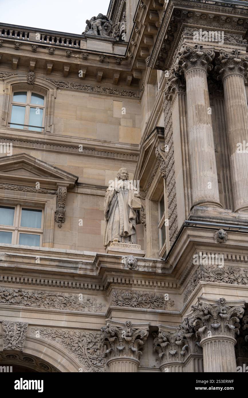 Historical statue stands prominently on the ornate facade of a grand ...
