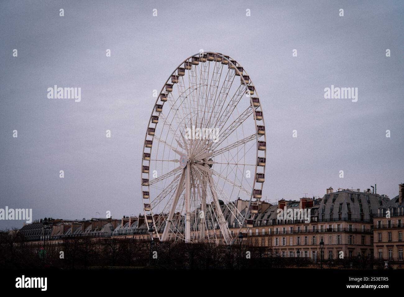 Parisian Ferris wheel stands tall against a moody sky in the city’s ...