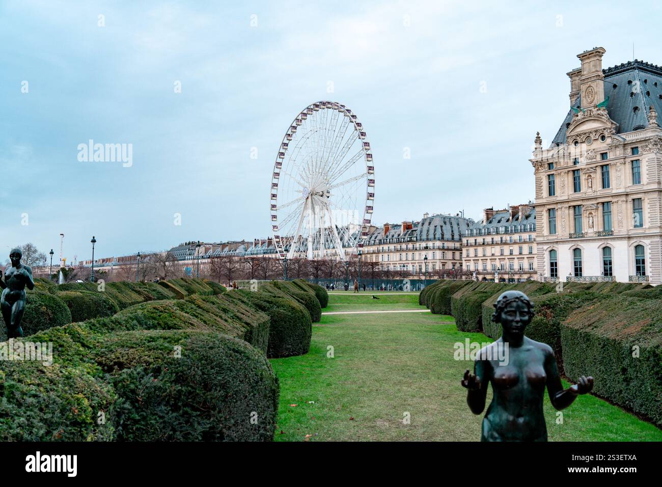 Visitors stroll through a garden featuring sculptures with a large ...