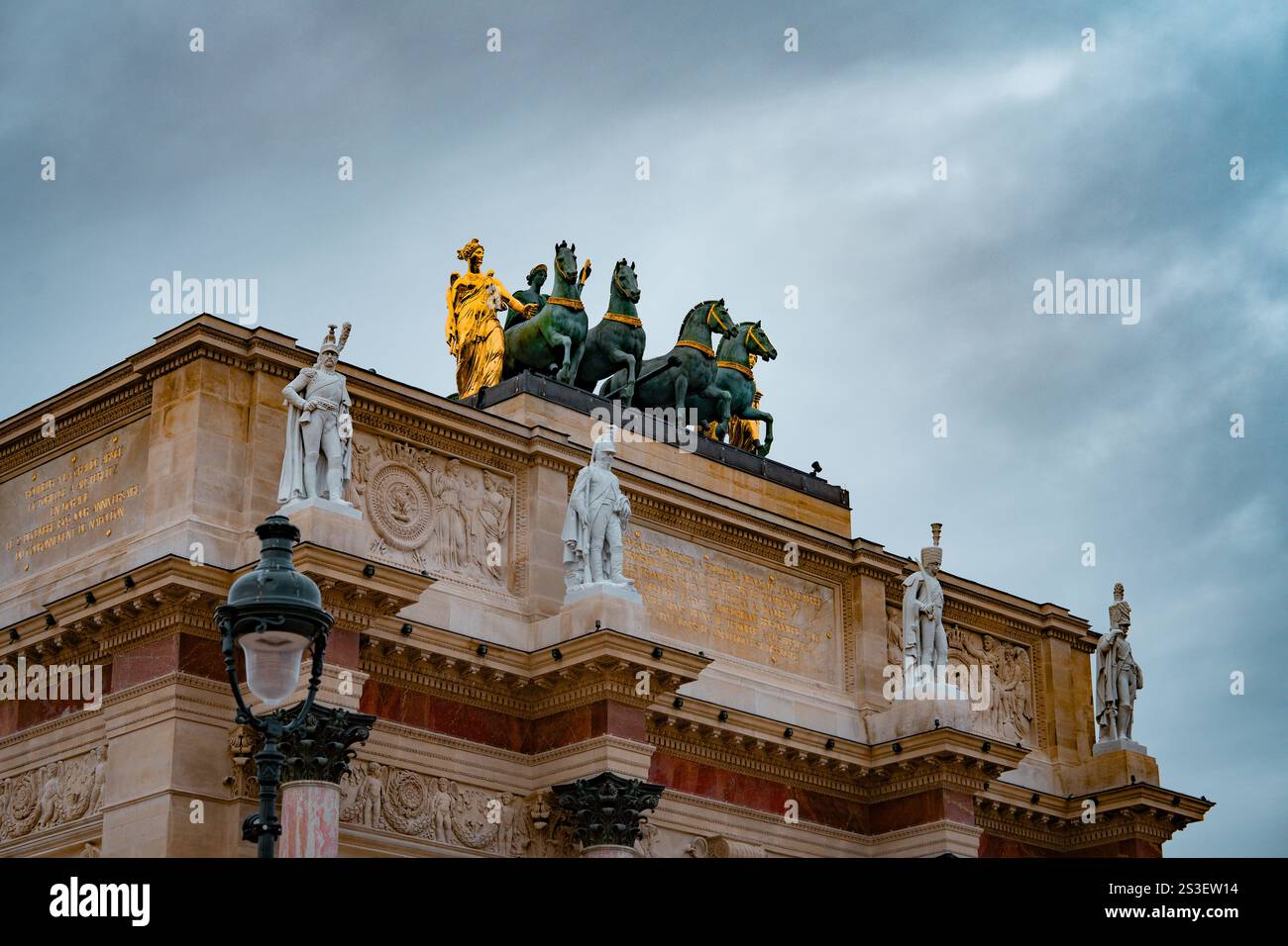 Statues and sculptures atop historic building under dramatic sky in ...