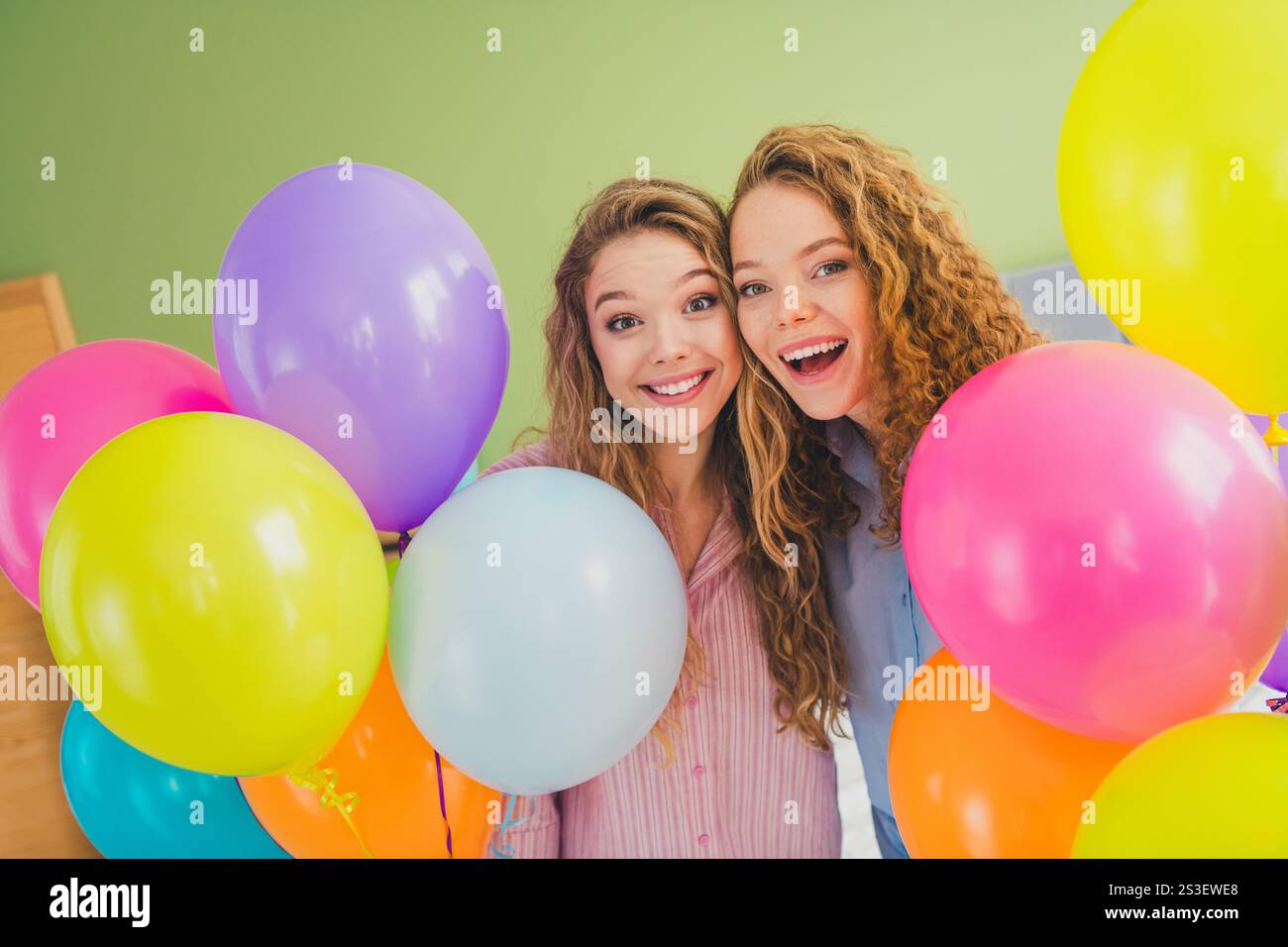 Photo of two pretty young females air balloons dressed enjoy wake up ...